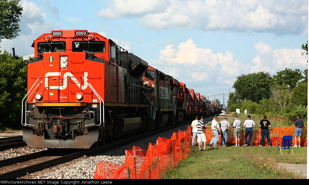 A CN westbound passes a group of railfans